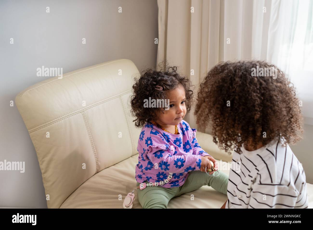Two mixed race siblings are thoughtfully looking at each other, A ...