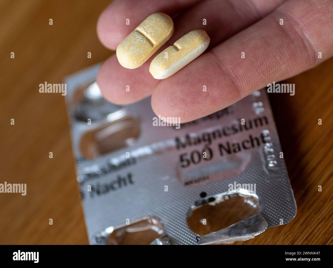 Berlin, Germany. 03rd Mar, 2024. A man holds two magnesium tablets in ...