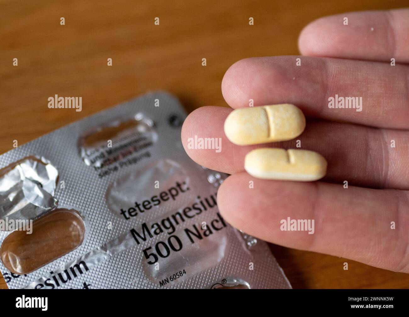 Berlin, Germany. 03rd Mar, 2024. A man holds two magnesium tablets in ...
