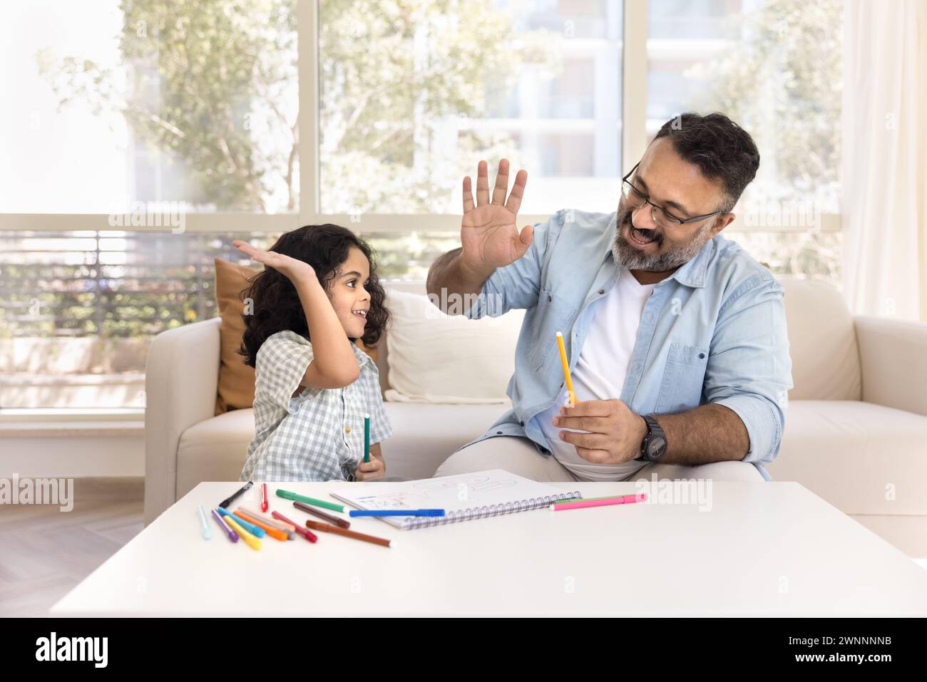 Happy Indian grandpa and sweet preschool granddaughter giving high five ...