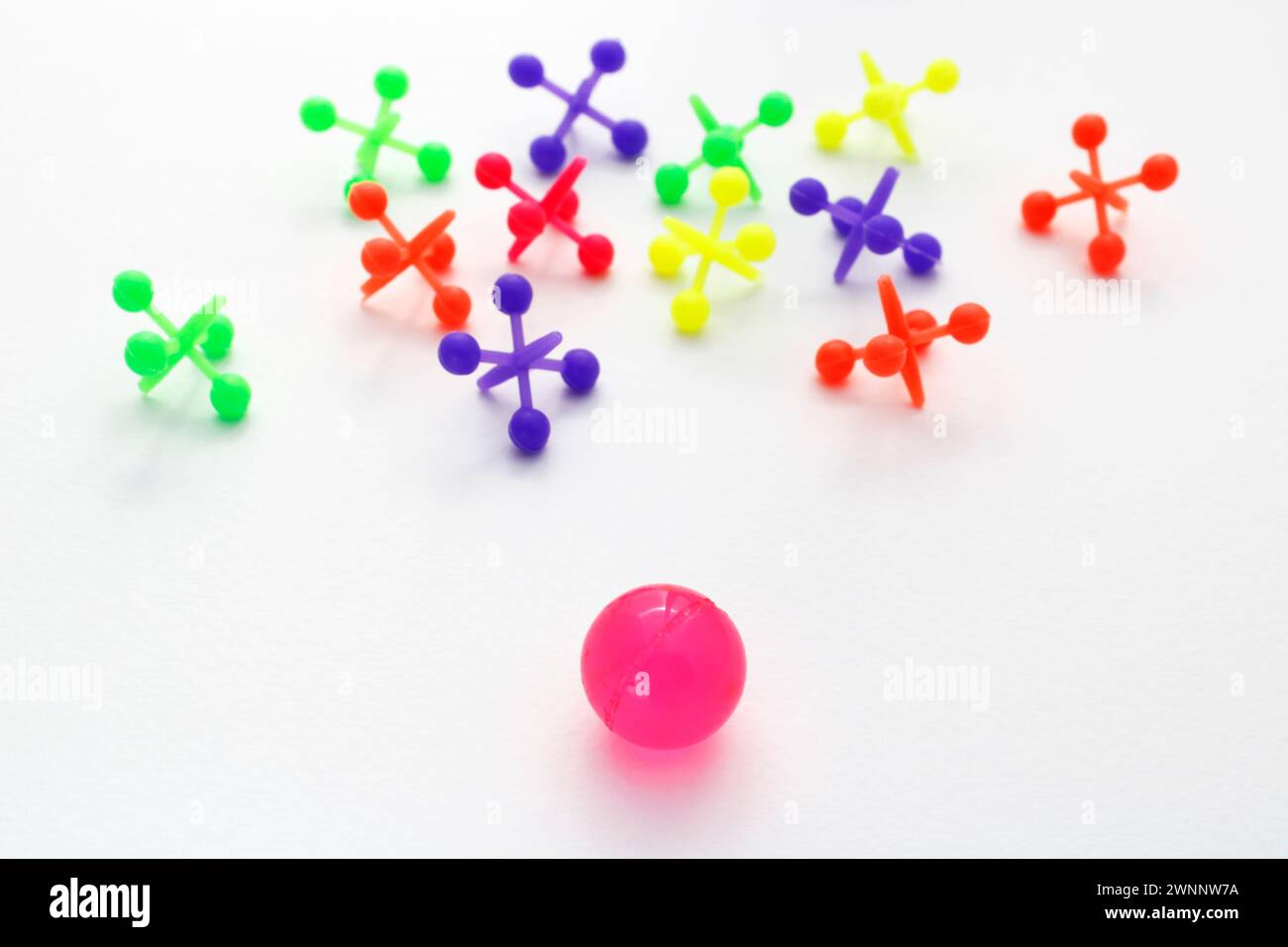 Pieces of colorful jack game next to their ball Stock Photo - Alamy