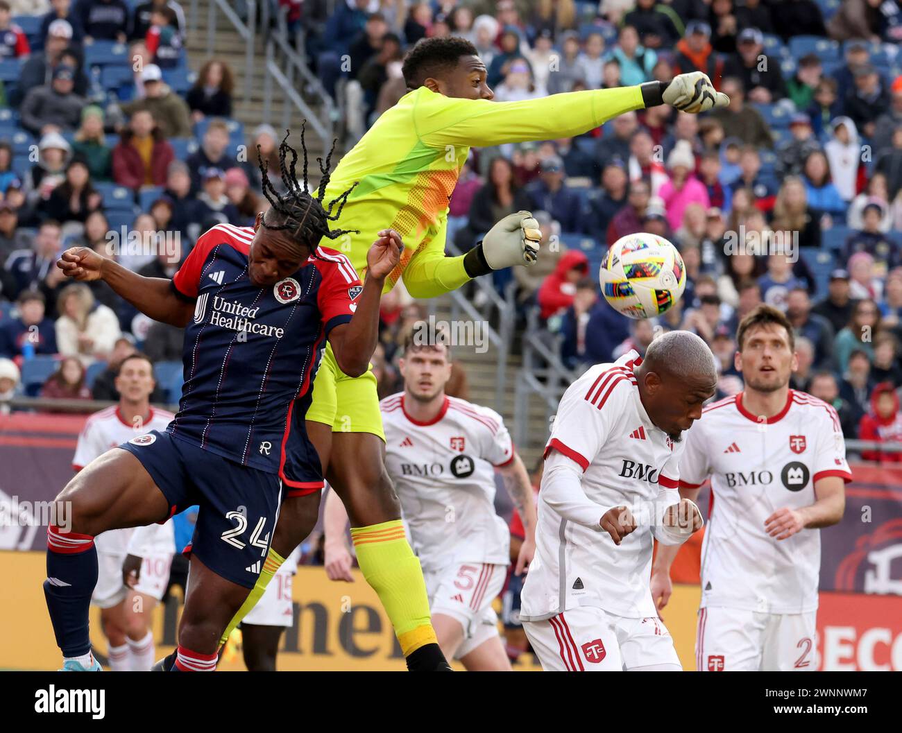 Toronto FC goalkeeper Sean Johnson punches the ball over New England ...