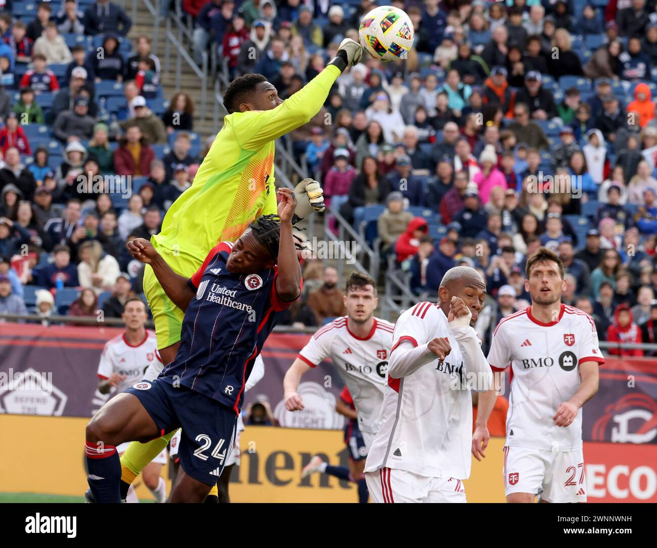 Toronto FC goalkeeper Sean Johnson punches the ball over New England ...
