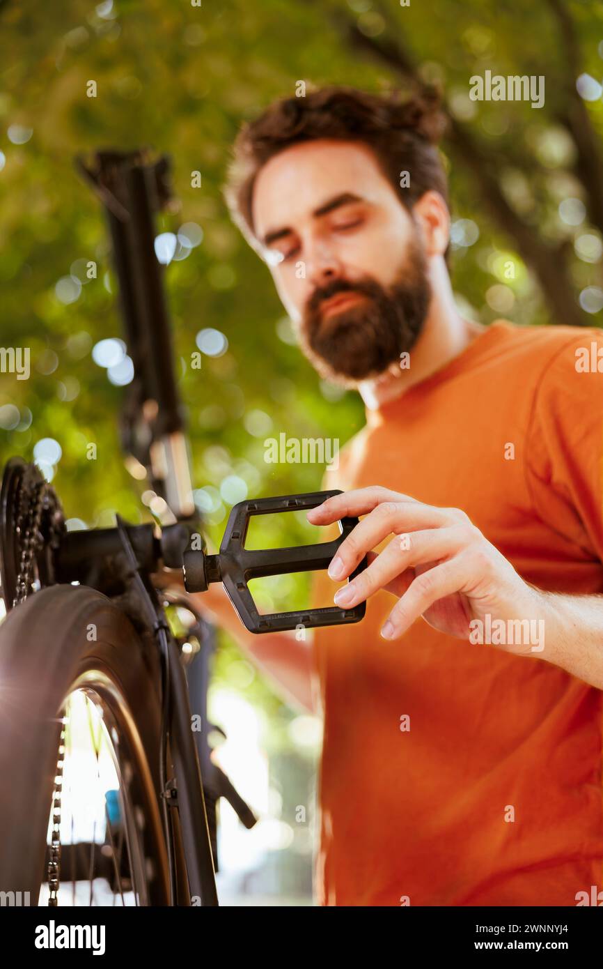 Sports-loving dedicated man repairing bicycle parts using professional ...