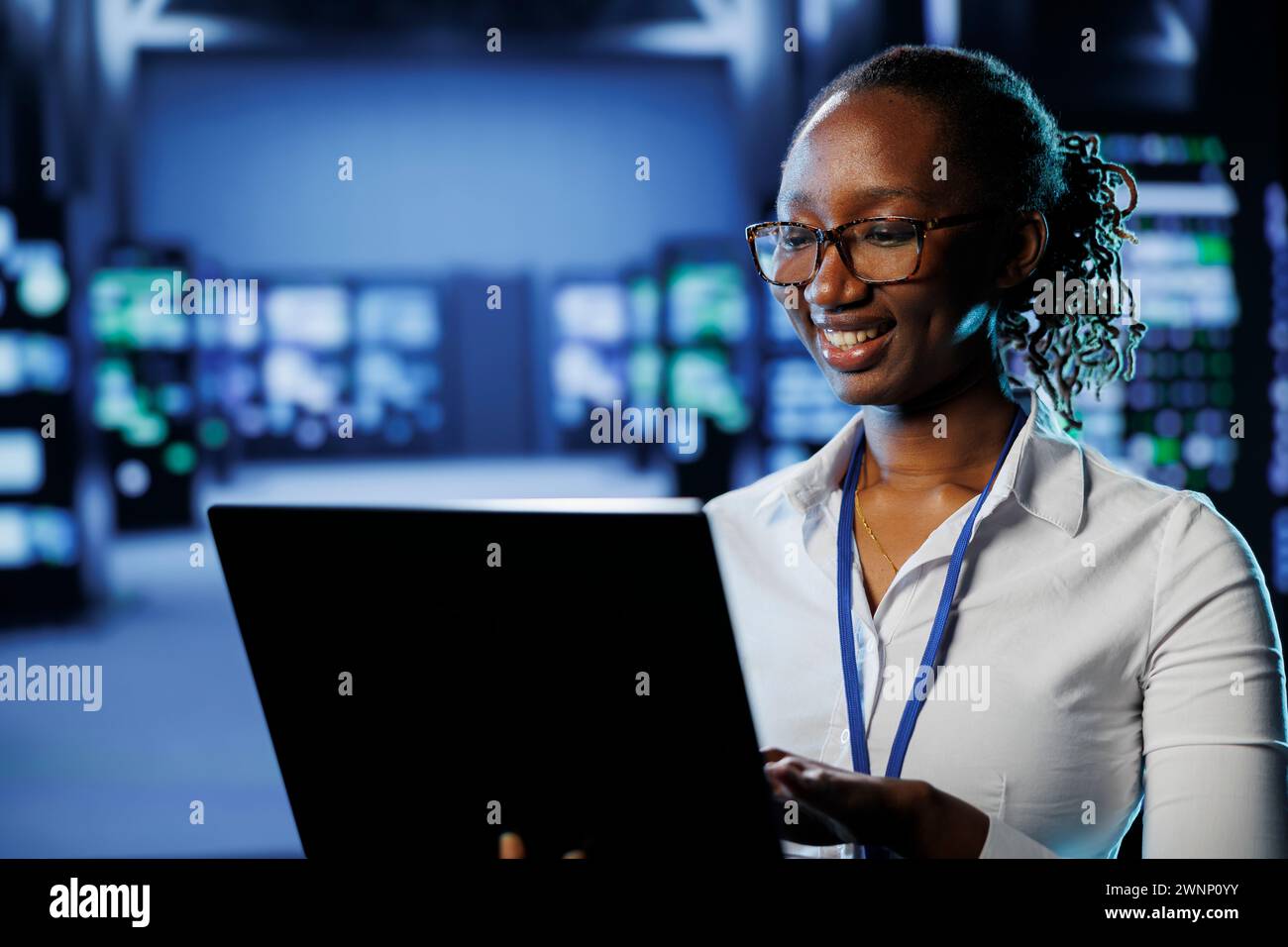 African american woman between server farm rows providing processing resources for businesses ...
