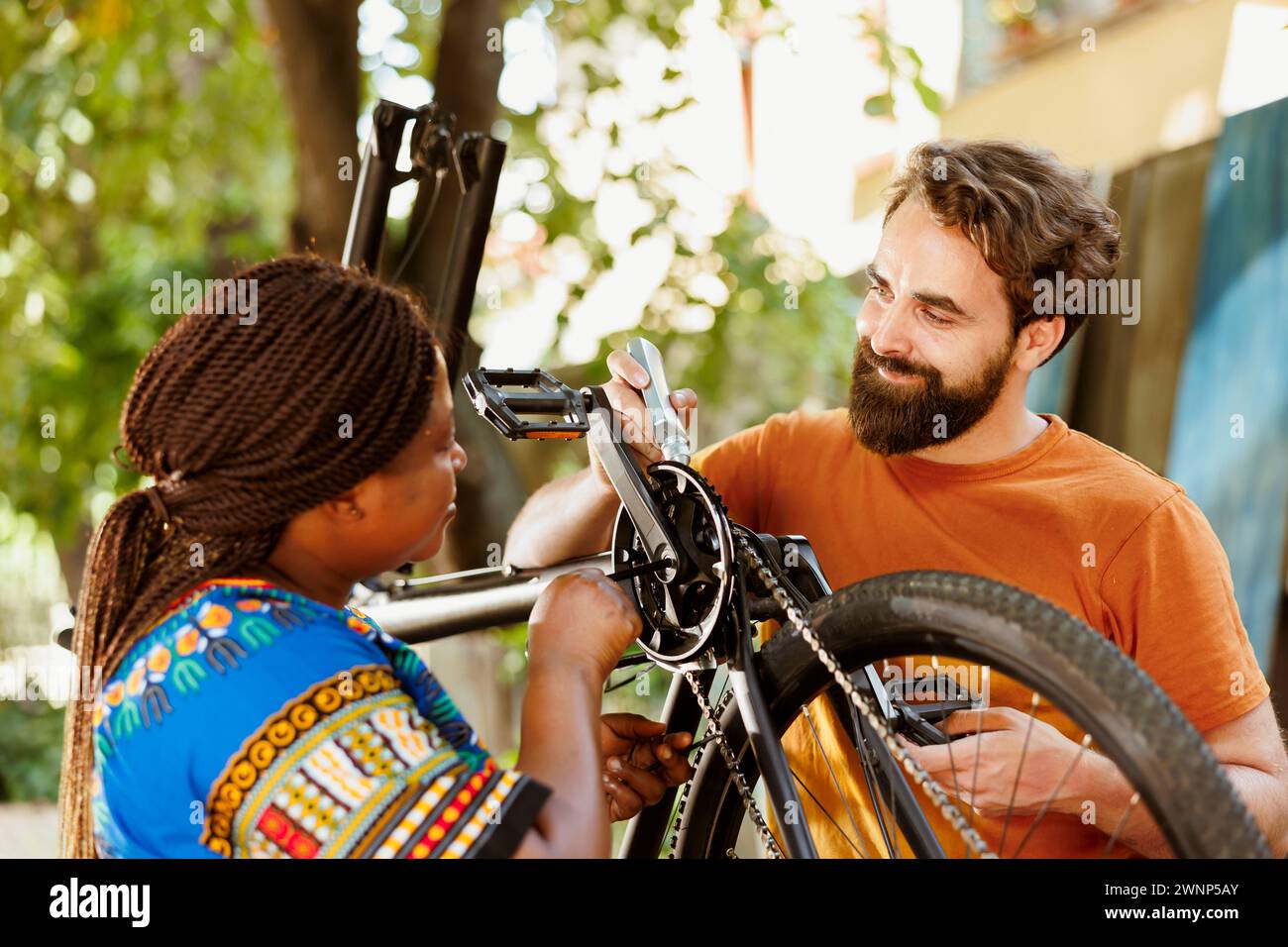 Healthy energetic caucasian man applying grease on bike chain while ...