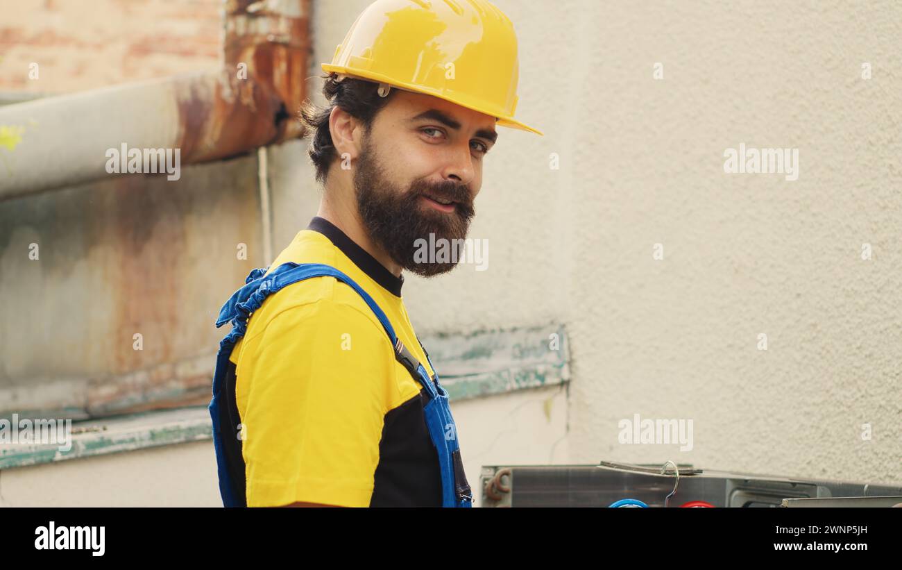 Portrait of qualified serviceman working on broken air conditioner ...