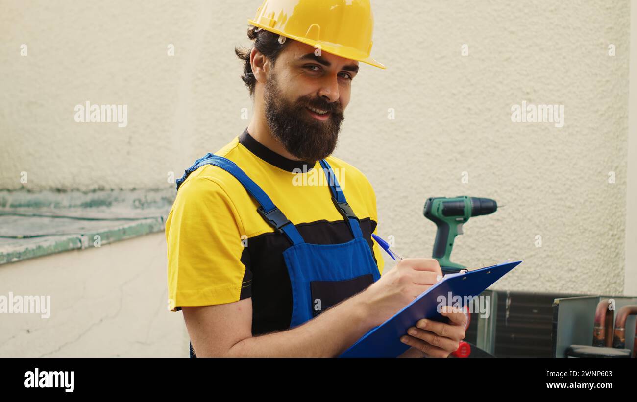 Portrait of certified mechanic commissioned for outdoor air conditioner ...