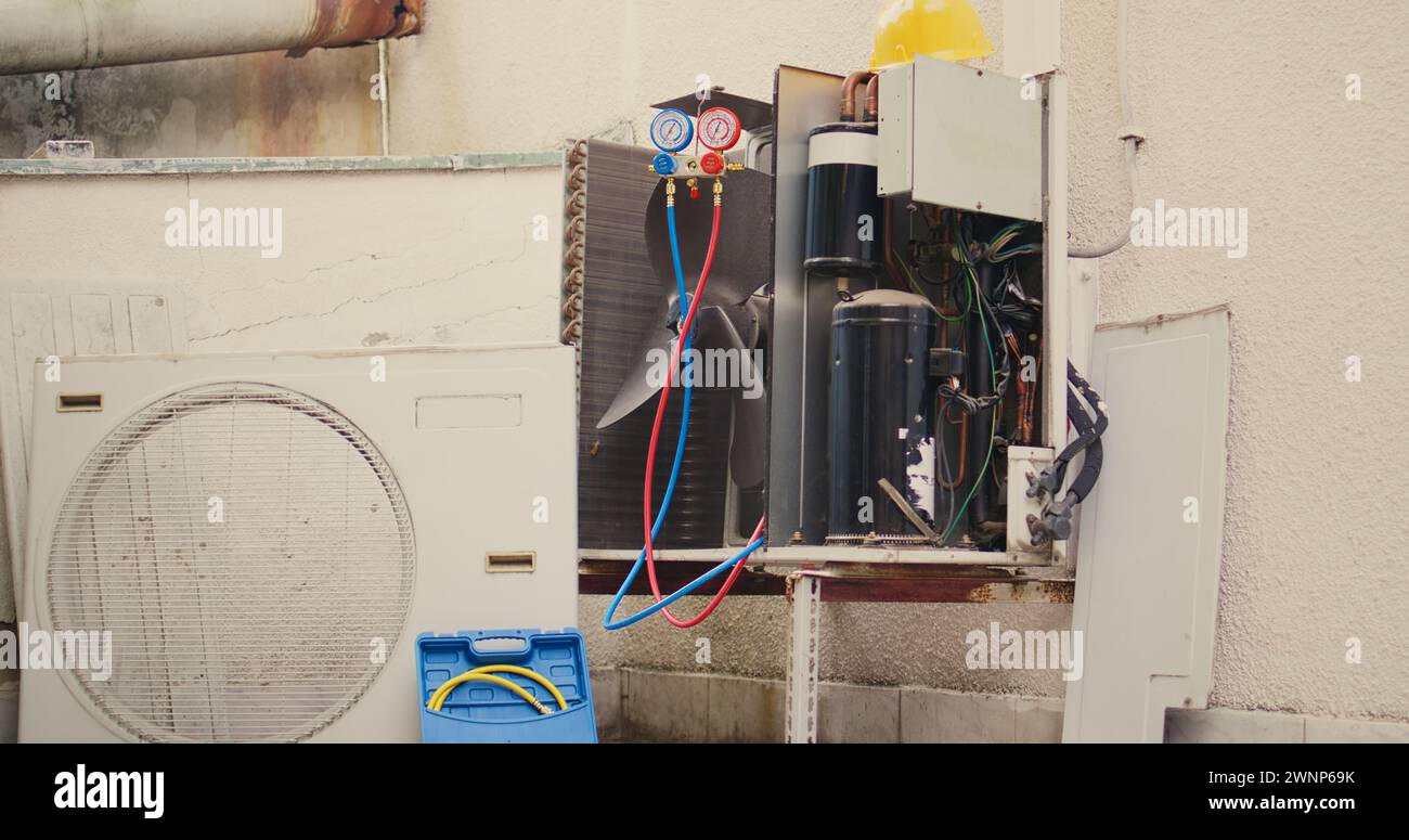 Revealing handheld camera shot of broken outdoor air cooling unit in ...