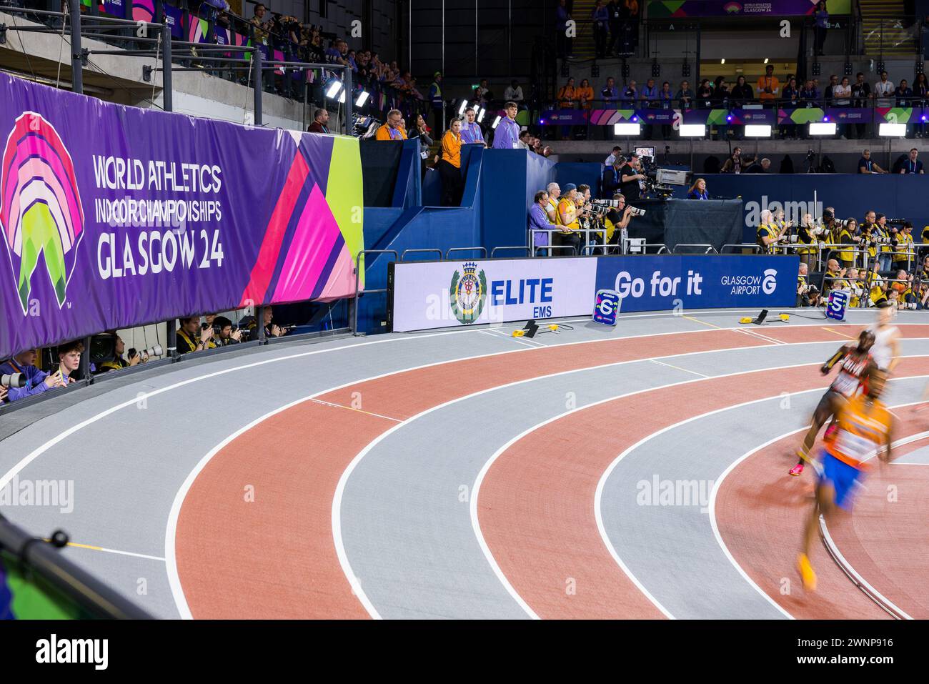 Glasgow, Scotland. 03 March 2024. Runners pass the Glasgow crash mat sign during the men’s 4x400 ...