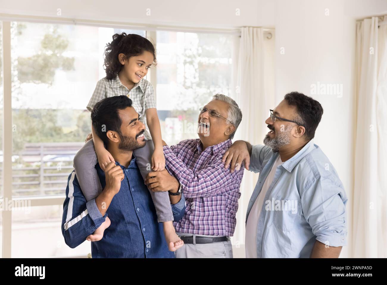 Cheerful Indian daddy, granddad and great grandpa playing with kid ...