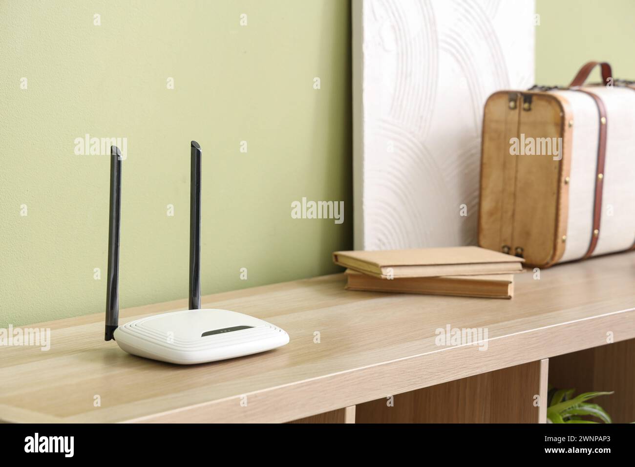 Modern wi-fi router on shelf near green wall, closeup Stock Photo - Alamy