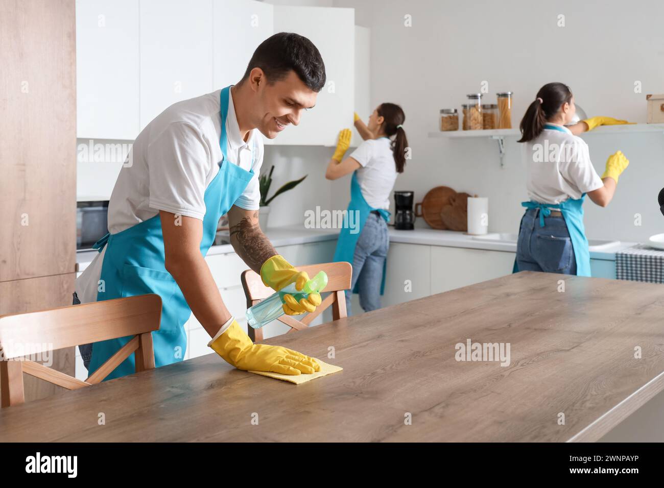Male janitor cleaning table in kitchen Stock Photo - Alamy