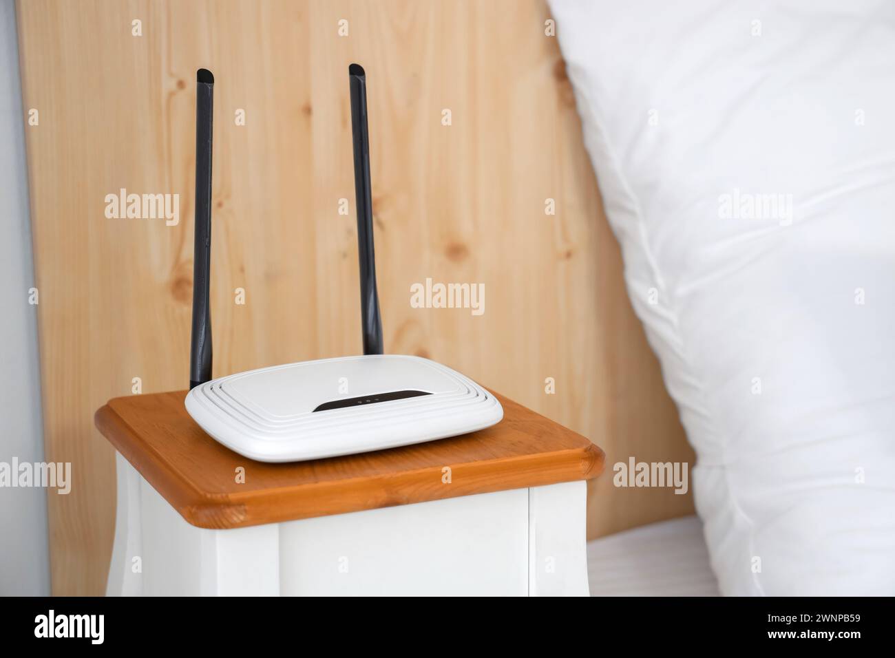 Modern wi-fi router on bedside table in room, closeup Stock Photo - Alamy