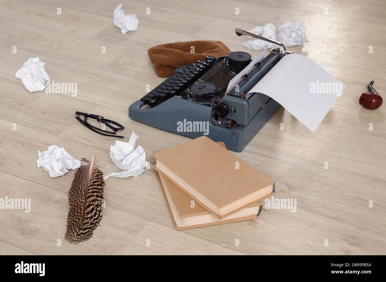 Vintage typewriter with books, crumpled paper and author's accessories ...