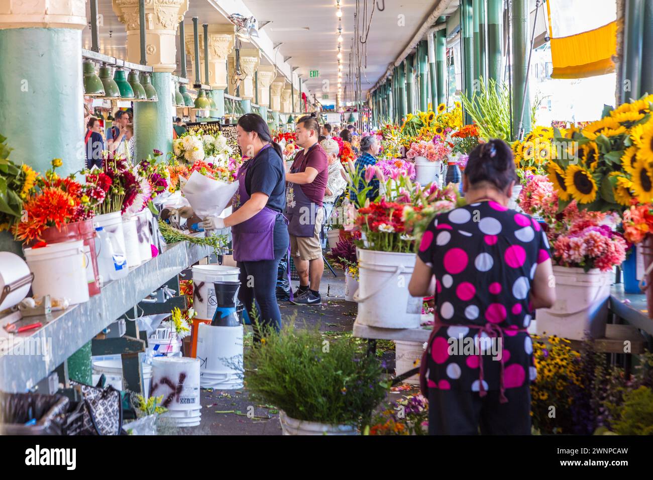 Men and women preparing flower arrangements for sale at the Pike Place ...