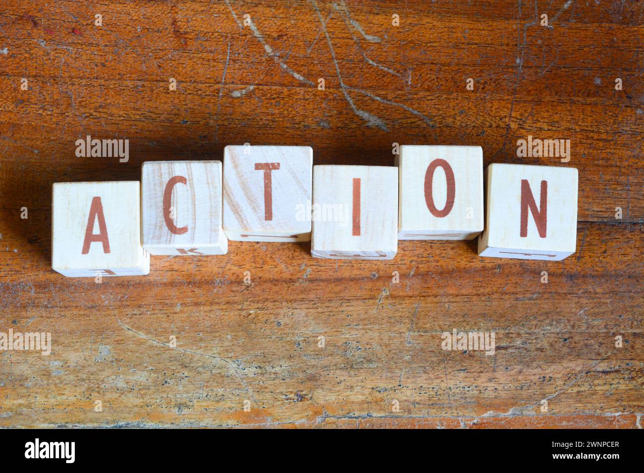 Photo of words with wooden block objects arranged into the word "ACTION ...