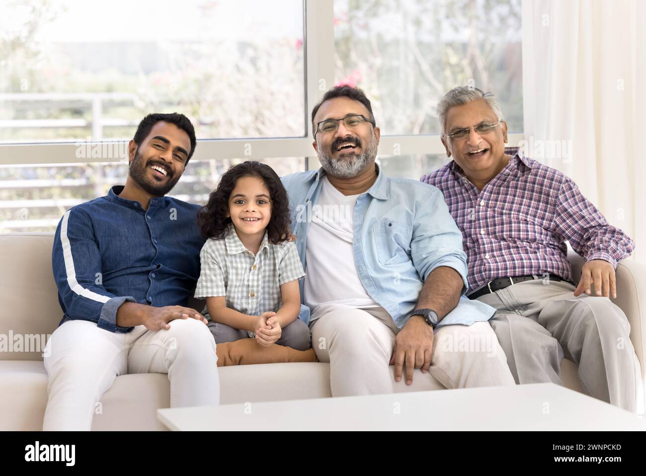 Happy child, father, grandpa, great granddad sitting on home sofa Stock ...