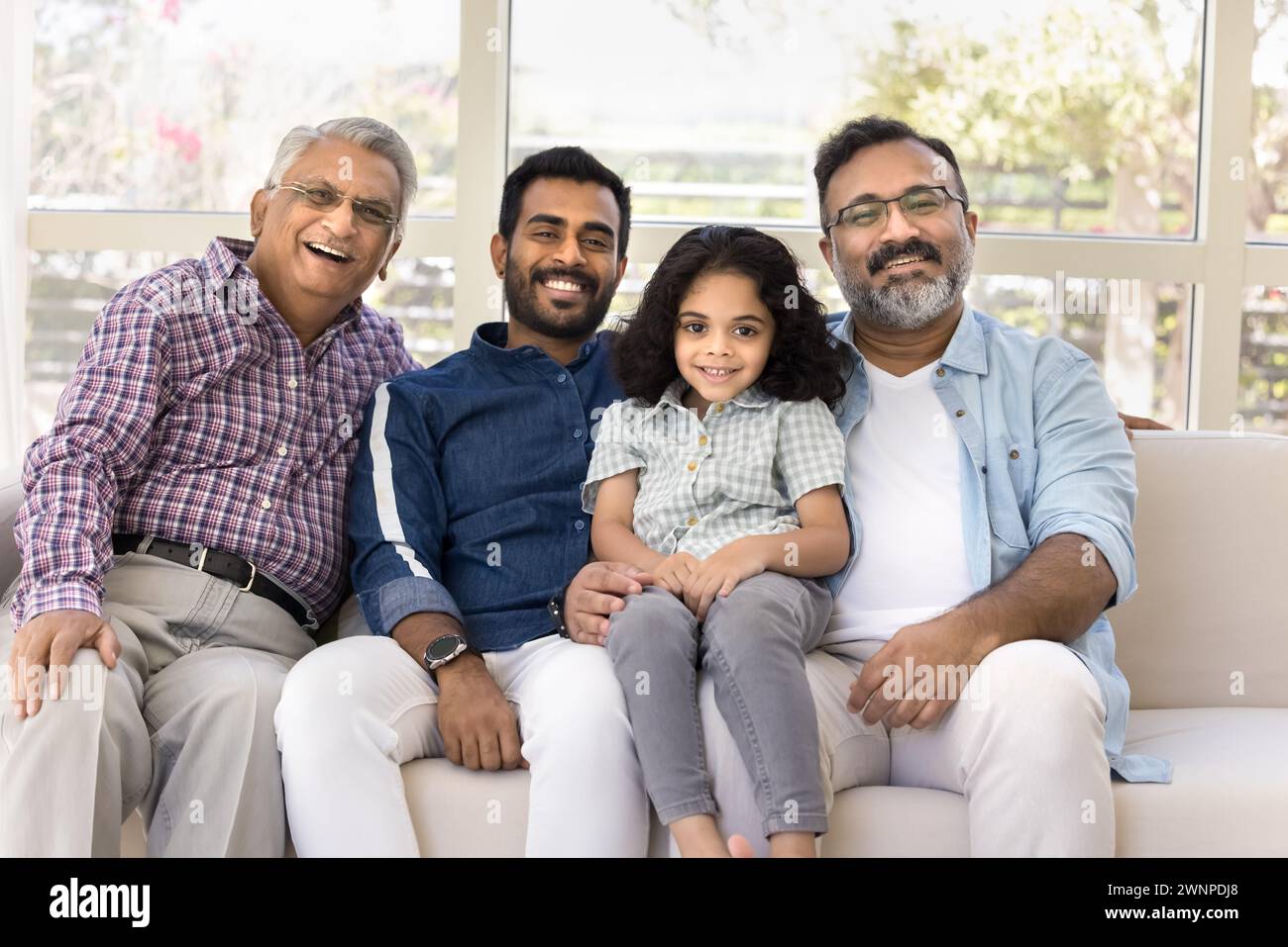 Cheerful kid and men of four family generations sitting close Stock ...