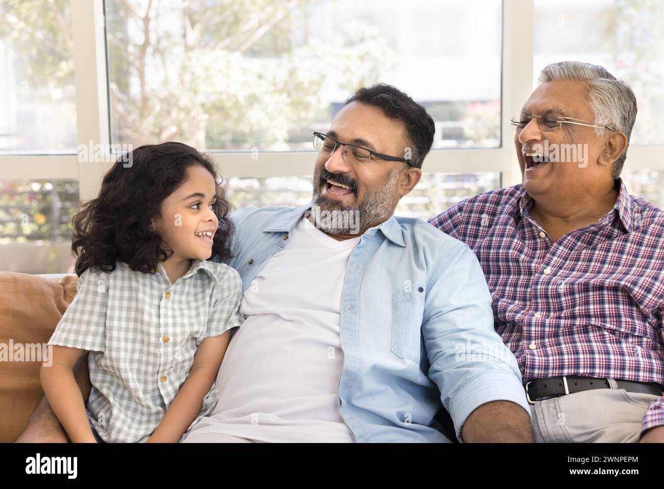 Cheerful Indian grandpa, older grandfather watching cute little ...