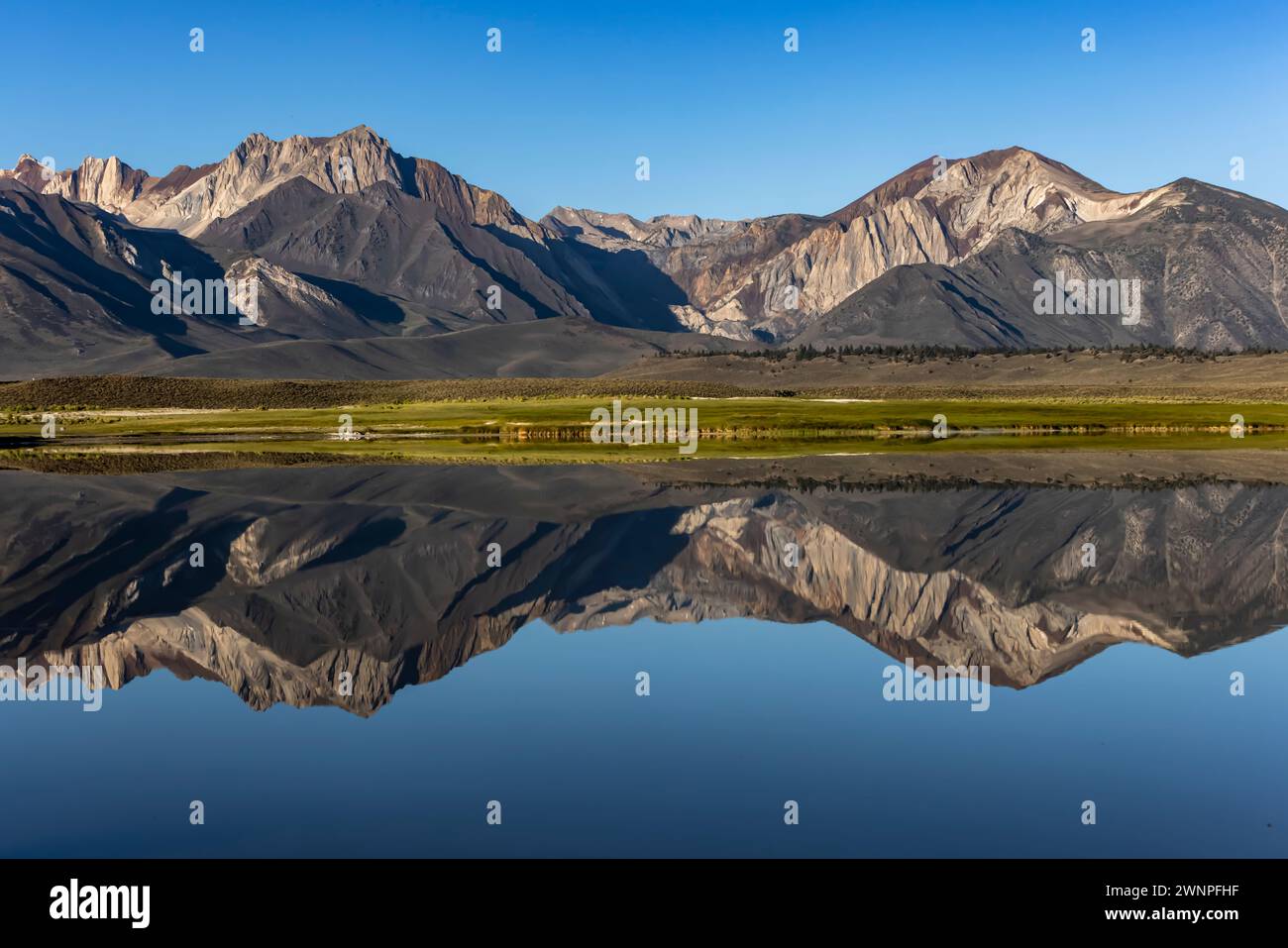 The Sherwin Mountains in the Eastern Sierras glow in the warm ...