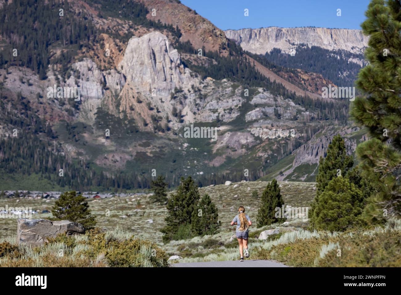 A jogger on the Mammoth Lakes Town Loop path with a view of Mammoth ...
