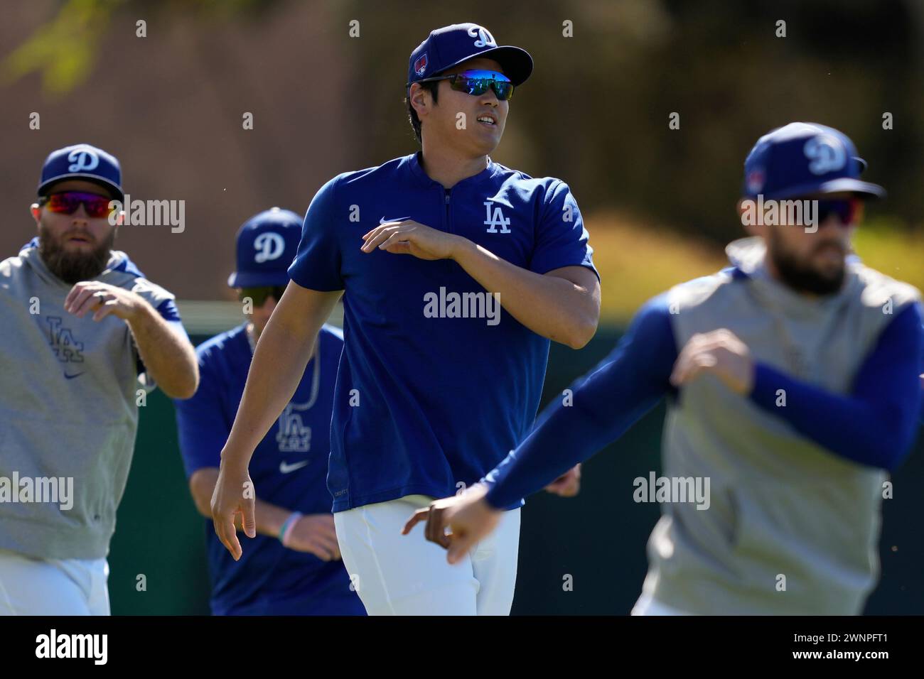 Los Angeles Dodgers' Shohei Ohtani, center, warms up during spring ...