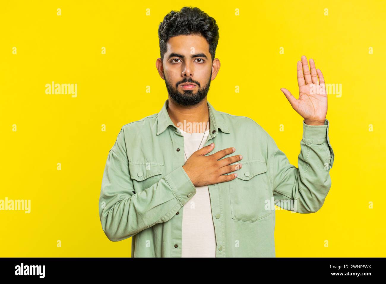 I swear to be honest. Sincere responsible Indian man raising hand to ...