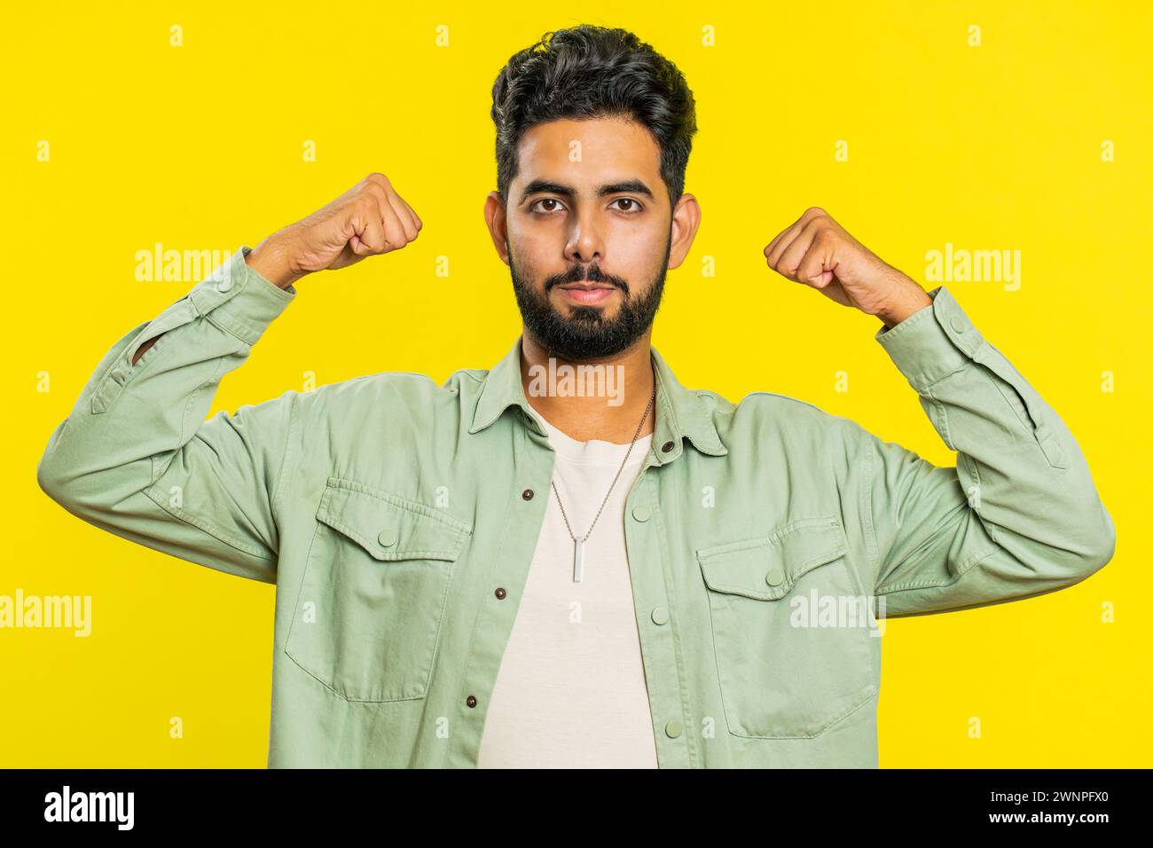 I am strong and independent. Young Indian man showing biceps and ...