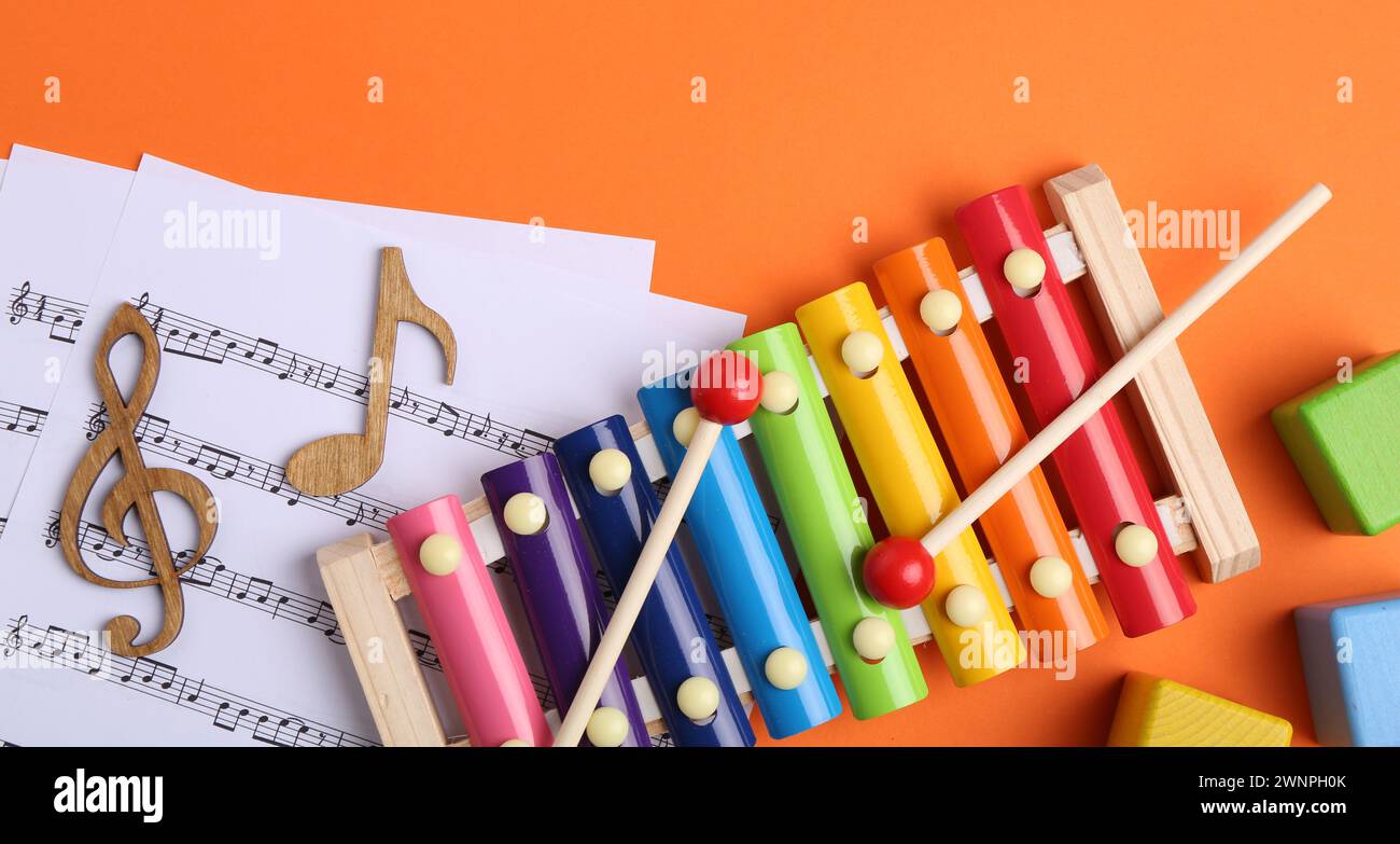 Tools for creating baby songs. Flat lay composition with xylophone on orange background Stock ...