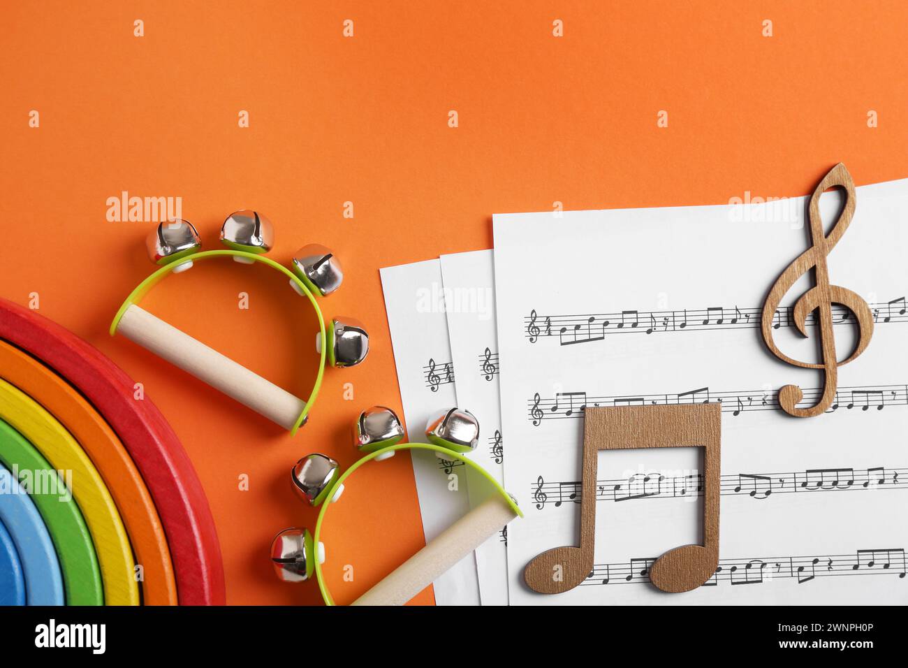 Tools for creating baby songs. Flat lay composition with tambourines for kids on orange ...