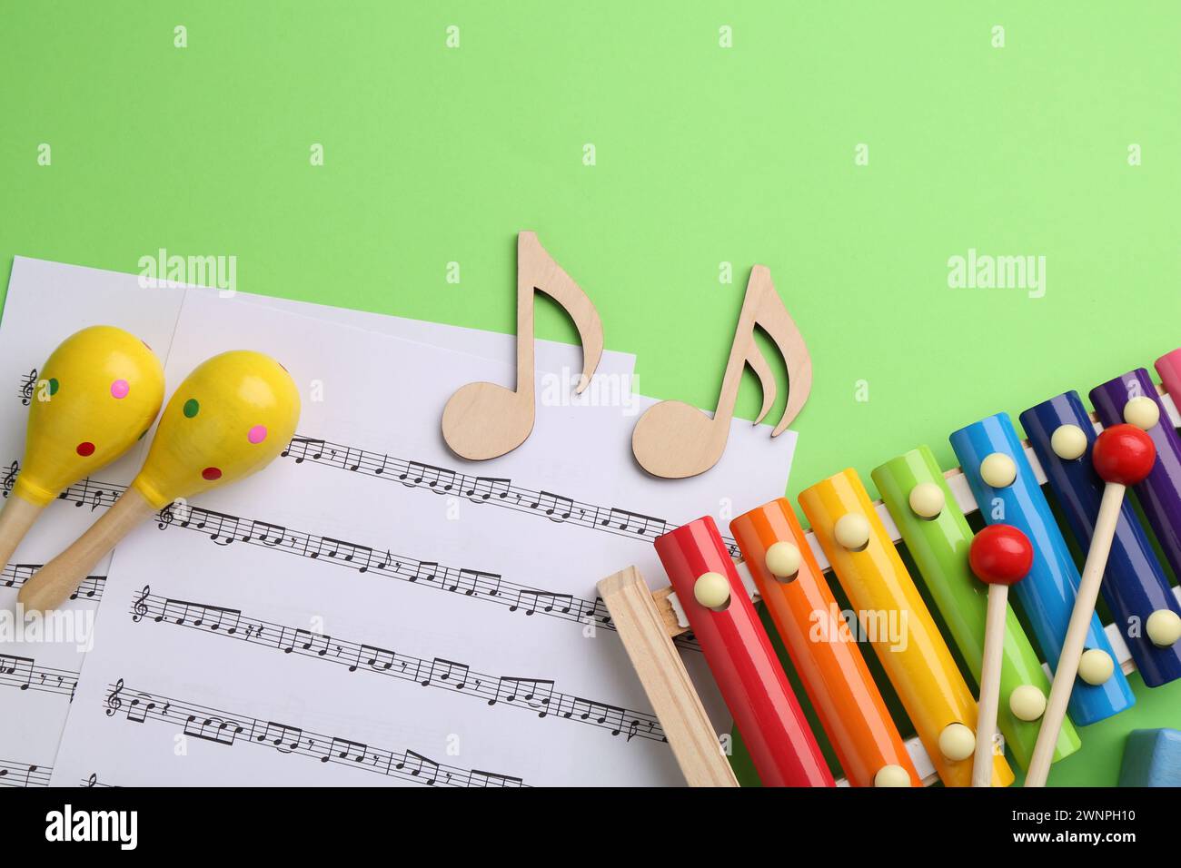 Tools for creating baby songs. Flat lay composition with maracas and xylophone on green ...