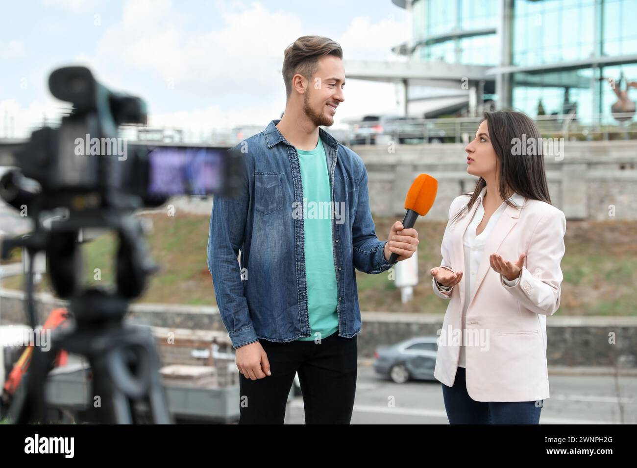 Young journalist interviewing businesswoman on city street Stock Photo ...