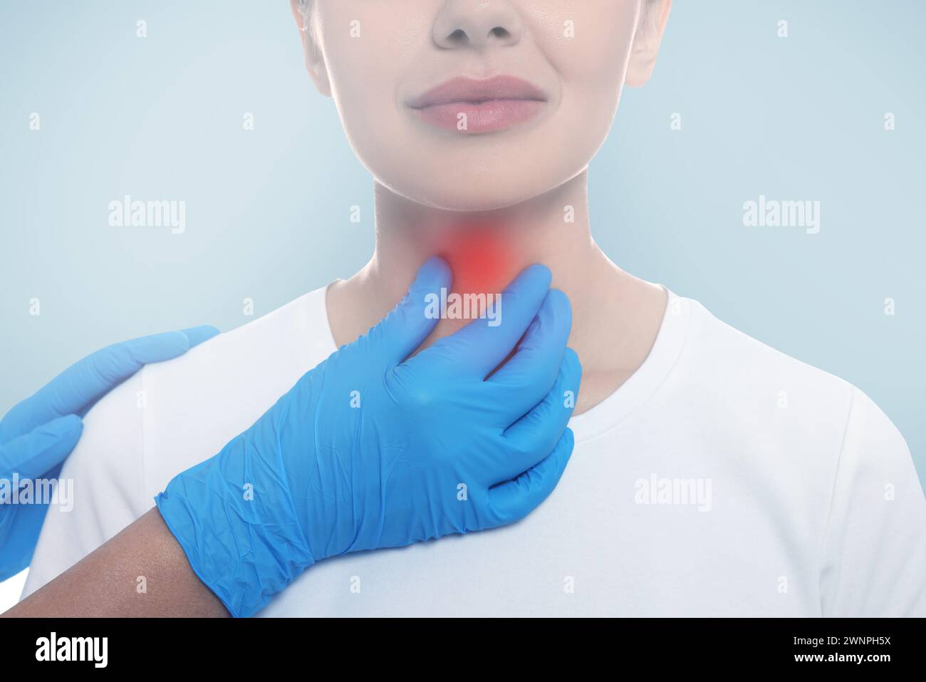 Endocrinologist examining thyroid gland of patient on light blue ...