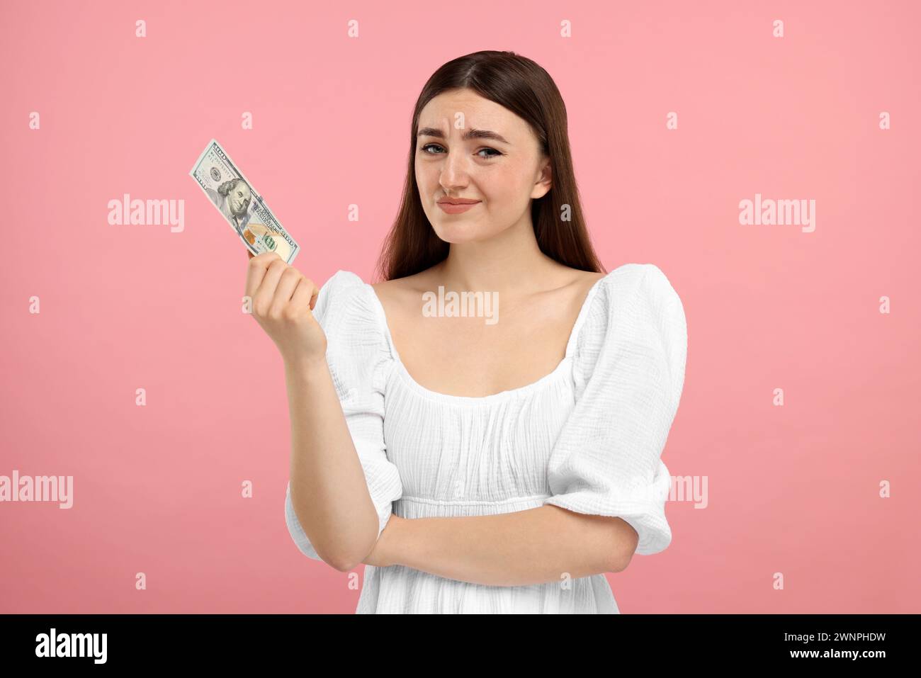 Sad woman with dollar banknote on pink background Stock Photo - Alamy