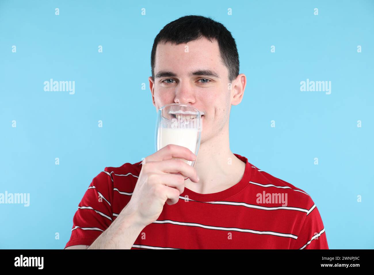 Milk mustache left after dairy product. Man drinking milk on light blue ...