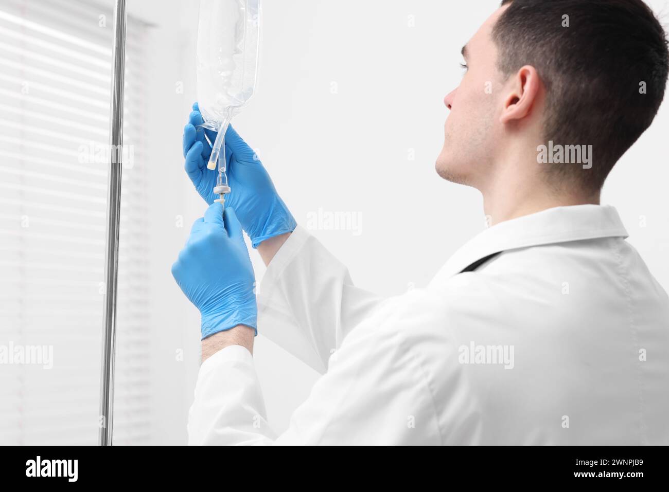 Doctor setting up IV drip in hospital Stock Photo - Alamy