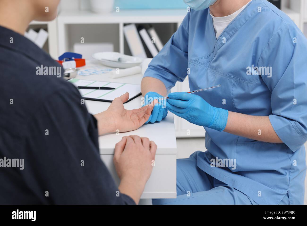 Laboratory testing. Doctor taking blood sample from patient at white ...