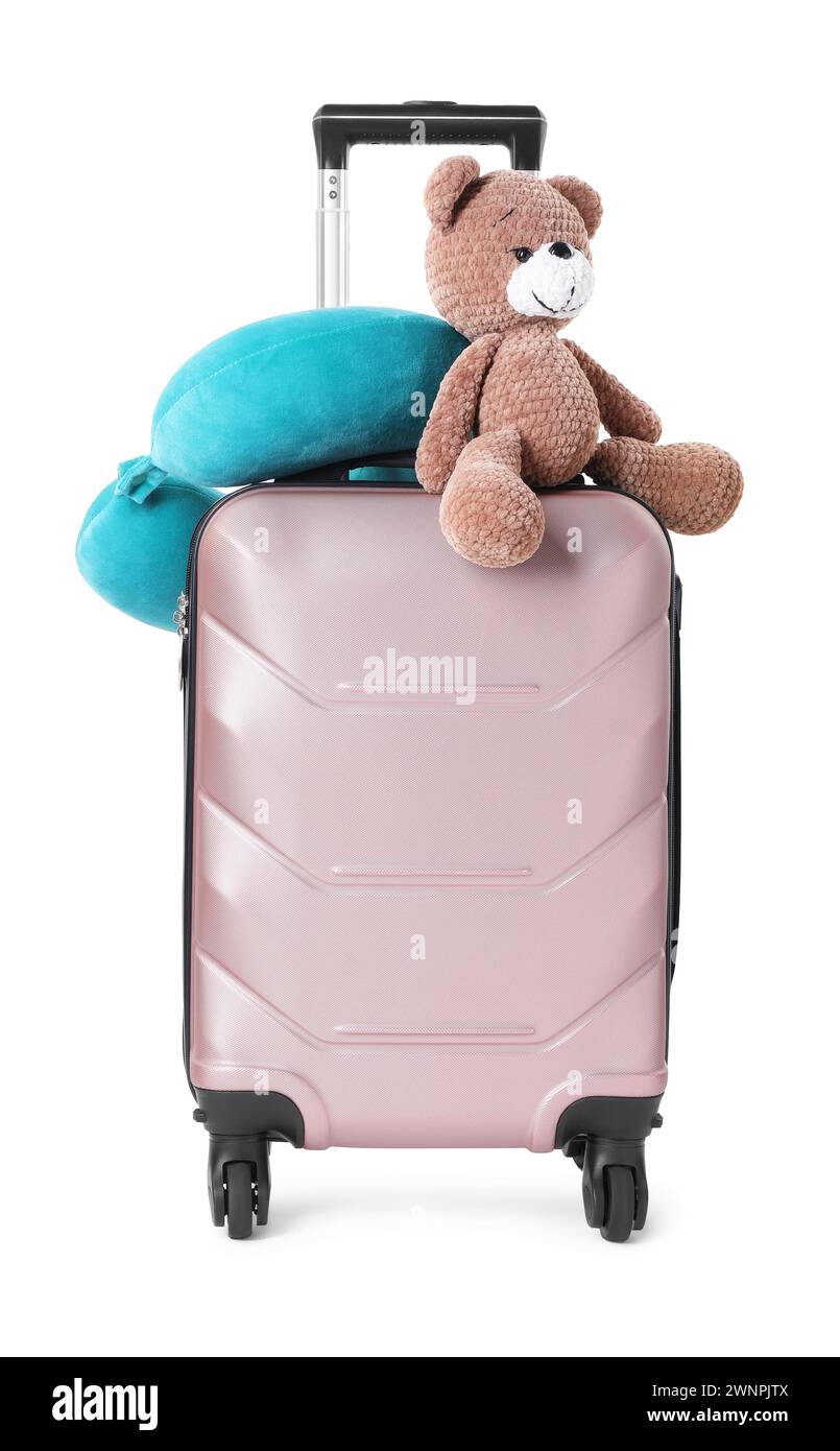 Light blue travel pillow and toy bear on suitcase against white ...