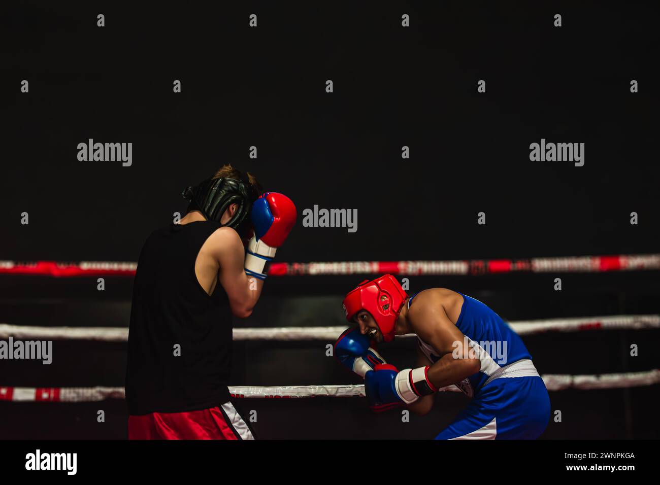 combat of two boxers over black background. Copy space Stock Photo - Alamy