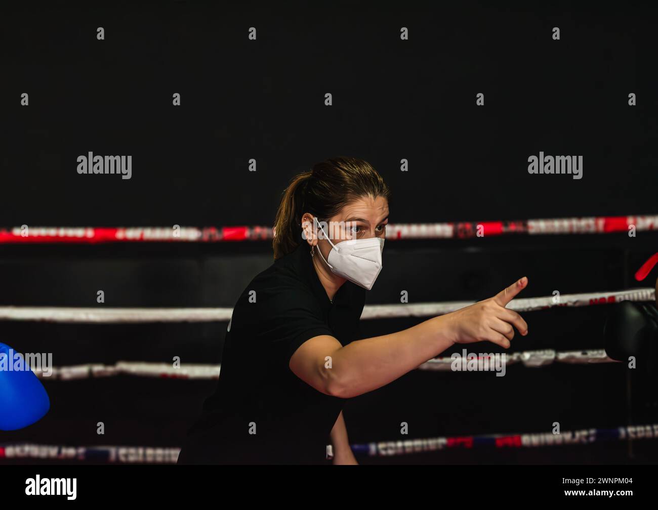 Female referee making the gesture with her arms to start the boxing ...