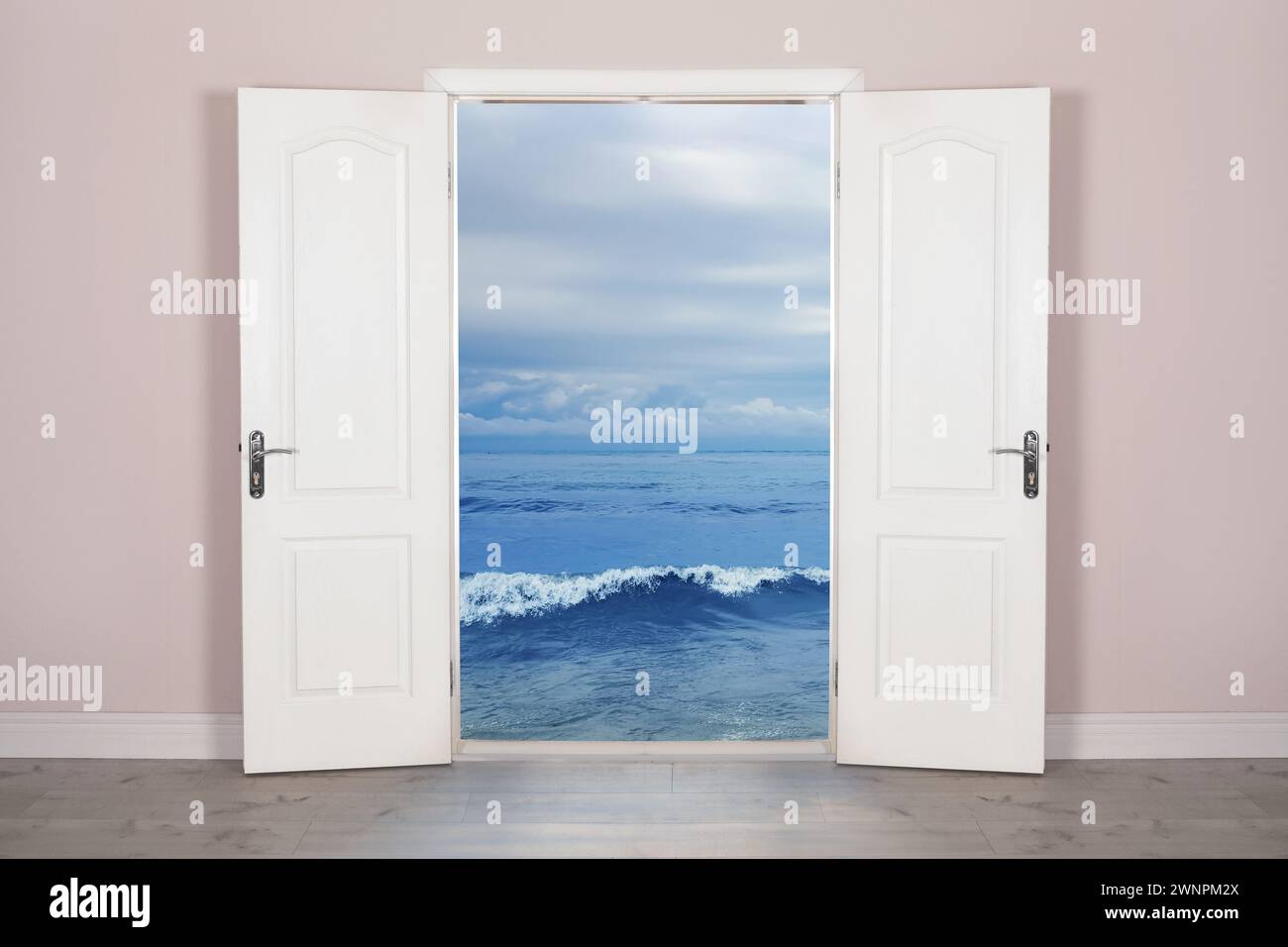 Sea with rolling waves visible through open door Stock Photo - Alamy