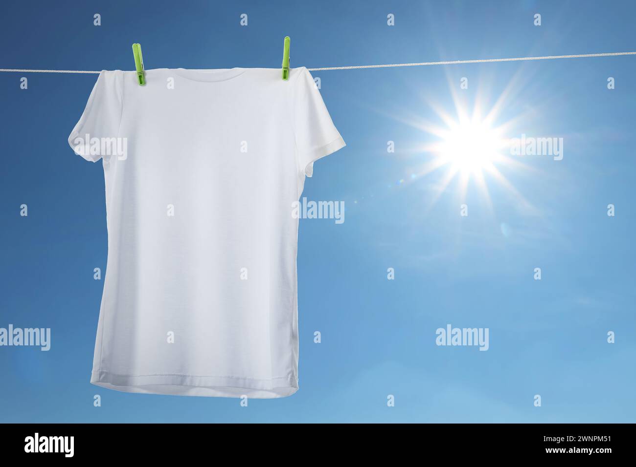 White t-shirt drying on washing line against blue sky Stock Photo - Alamy