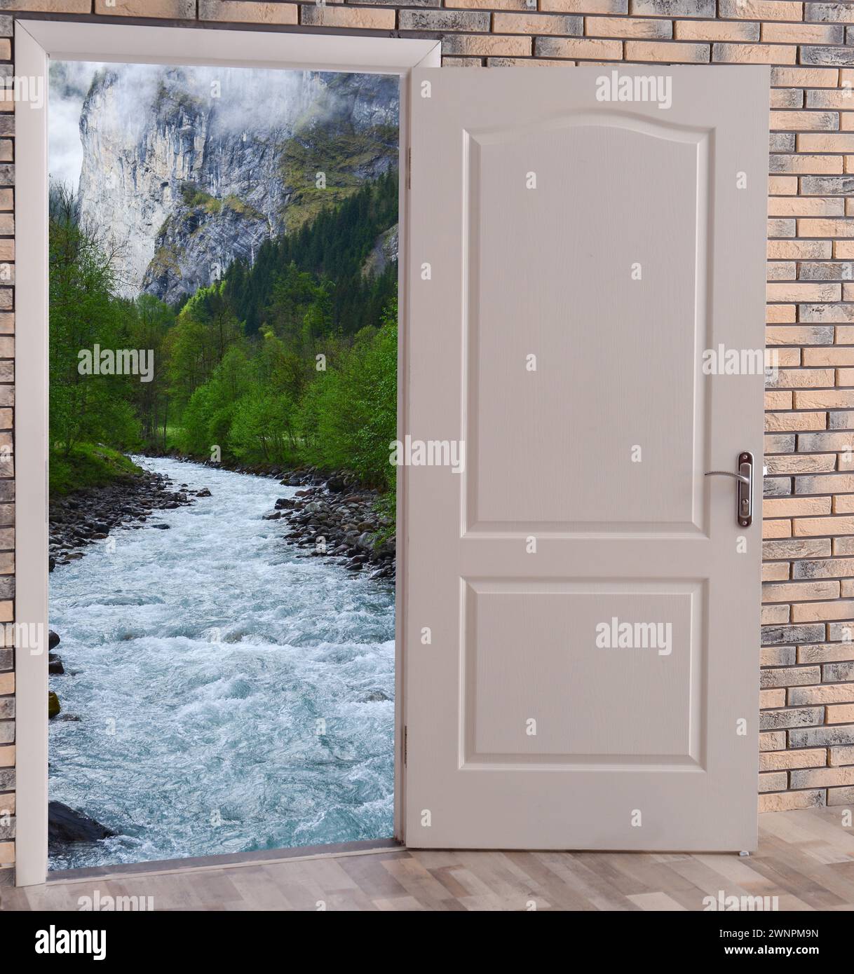 Open door in brick wall inviting to visit mountains Stock Photo - Alamy