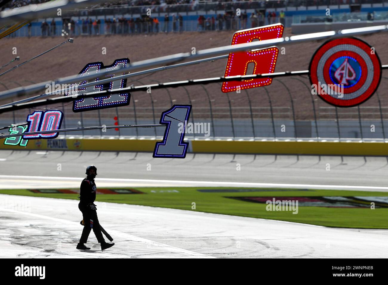 A pit crew member clears debris off pit row during a NASCAR Cup Series ...