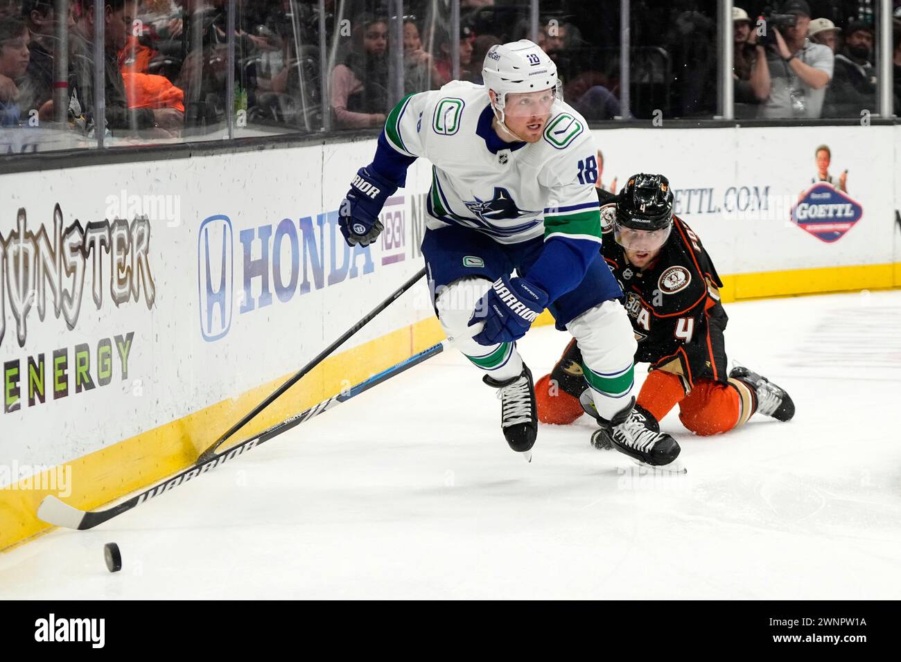 Vancouver Canucks center Sam Lafferty, left, takes the puck as Anaheim ...