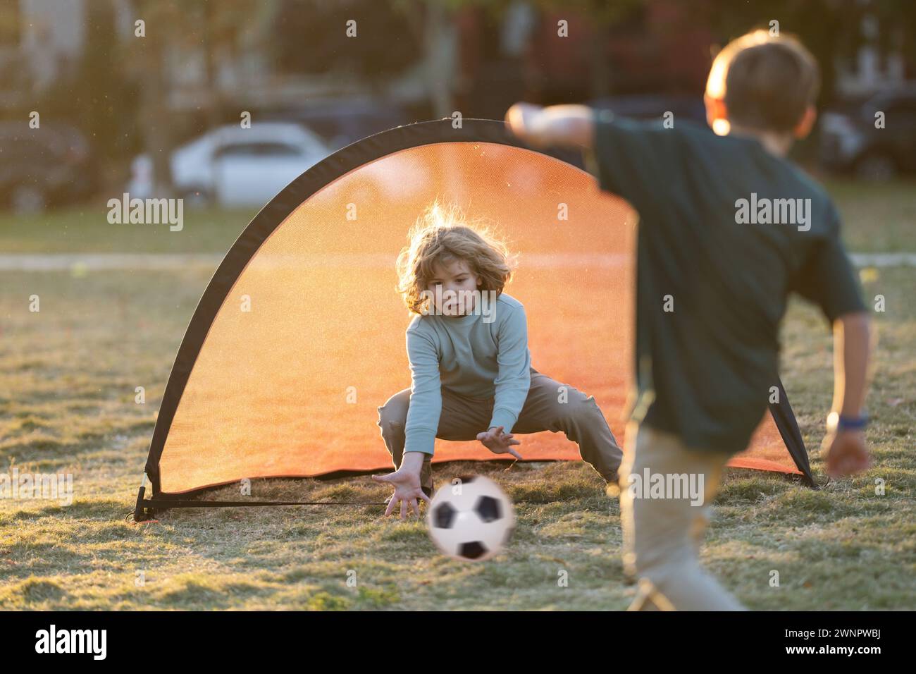 Child boy football or soccer player in action on soccer stadium kicking ...
