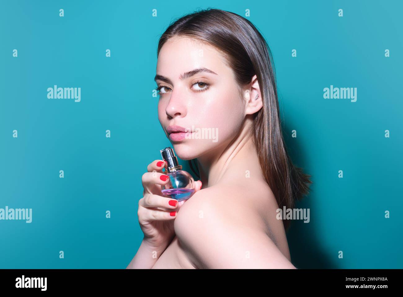 Perfume bottle. Woman with spray aroma perfume. Woman holding a perfumes bottle. Beautiful girl ...
