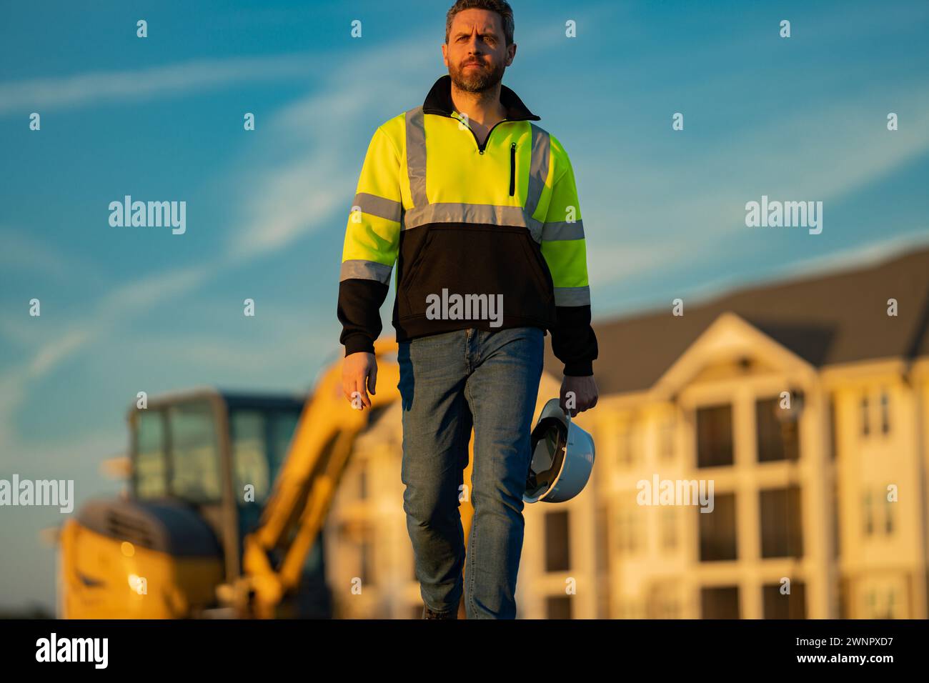 Man at construction site. Worker constructor in hardhat. Construction ...