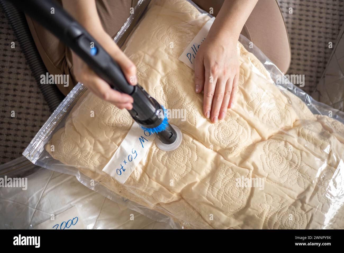 The girl pumps out air with a vacuum cleaner from a vacuum bag with ...